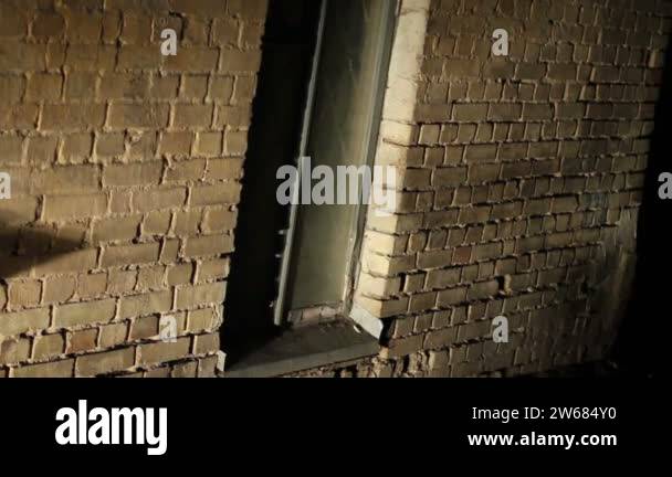 Scary place, grated window in old brick wall, abandoned building ...