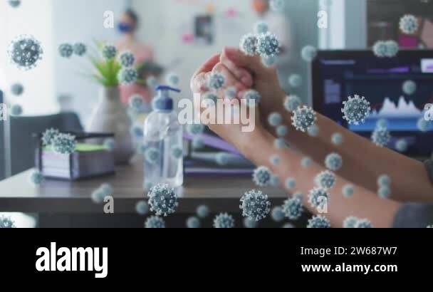 Covid-19 cells floating against mid section of woman sanitizing her ...