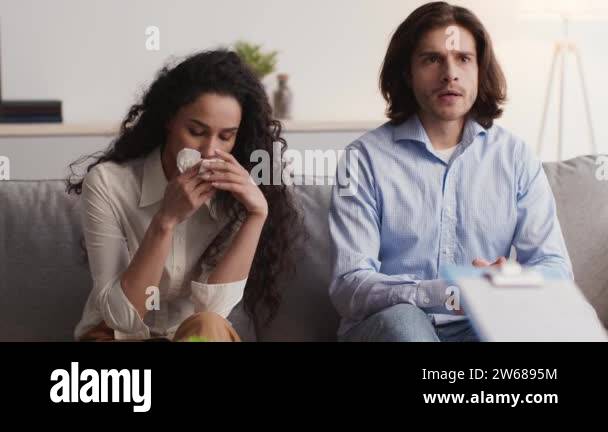 Emotional man speaking about his problems with wife, sad woman crying ...