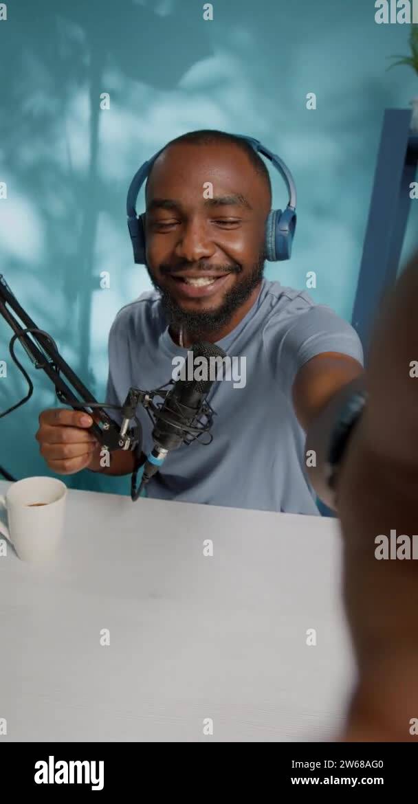 Vertical video: POV of vlogger holding camera to film video in studio ...