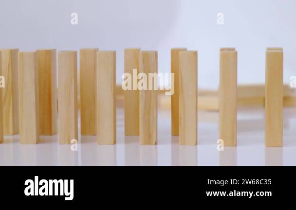 Domino effect, row of wooden domino falling down on white background ...