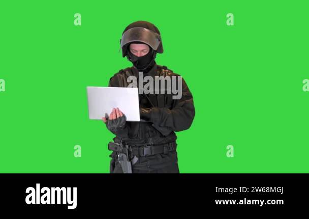 Masked Police Officer Using a Laptop Computer on a Green Screen, Chroma ...