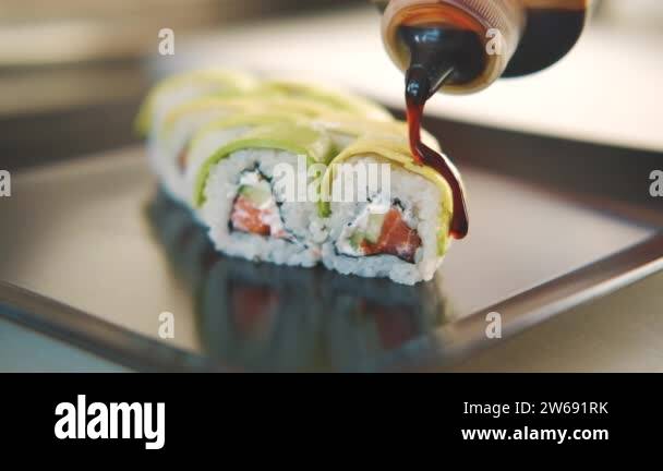 A process of preparation of sushi Green Dragon, chef making sushi roll ...