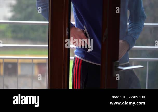 man thief enters the house from the balcony window with a gun pistol ...