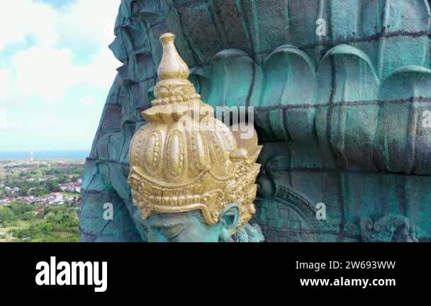 Close up aerial view of Vishnu riding Garuda. Giant copper blue and ...