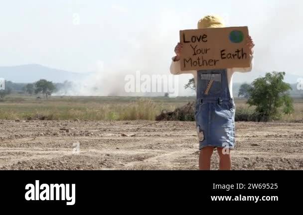 The little child girl holding "Love Your Mother Earth" Poster showing a ...