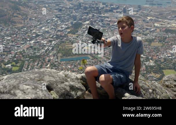 Young travel blogger boy. Kid posing in front of phone. A young boy in ...