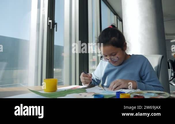 Cute teacher conducts art lesson, drawing. Shows the child how to paint ...