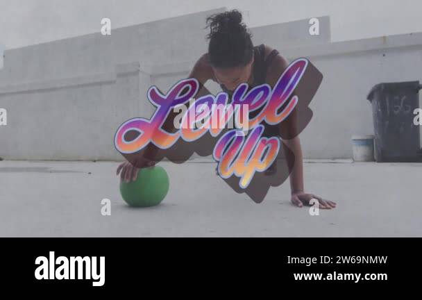 Animation of level up text over mixed race woman doing push ups on a ...