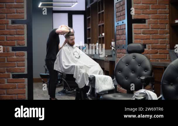 The process of mens haircut in a stylish barbershop with a black and ...