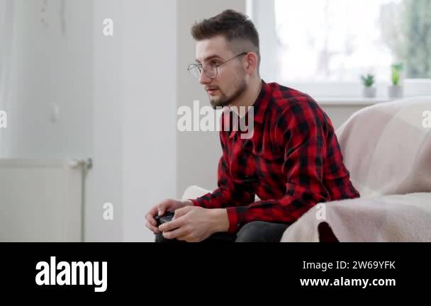 Side view of exhausted male gamer using game controller sitting on ...