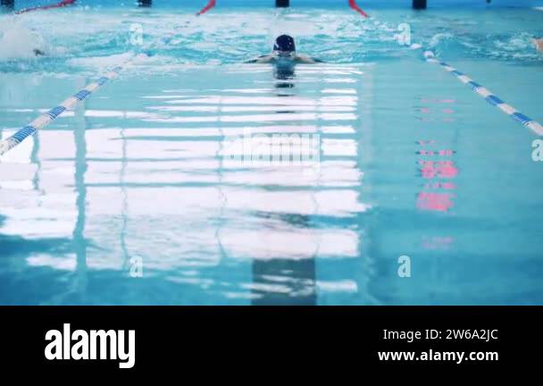 Slow motion of a male swimmer crossing the pool in a front view Stock ...
