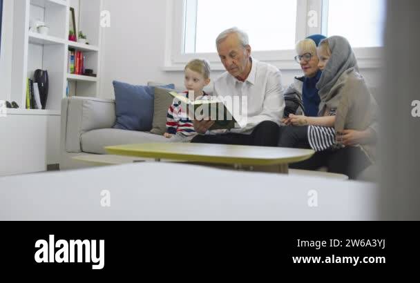 Traditional muslim family grand parents with children reading Quran and ...