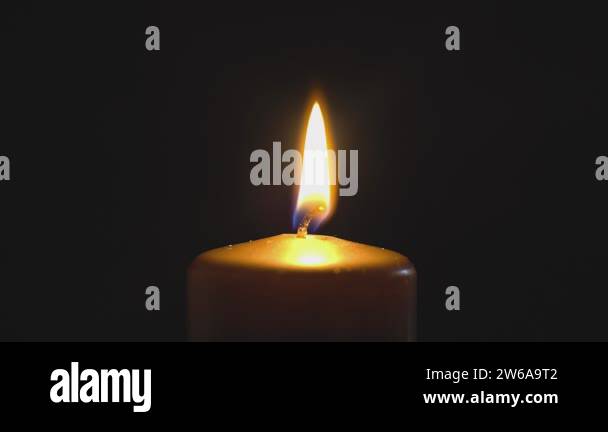 Single big yellow candle flame lights and extinguish, isolated on a ...