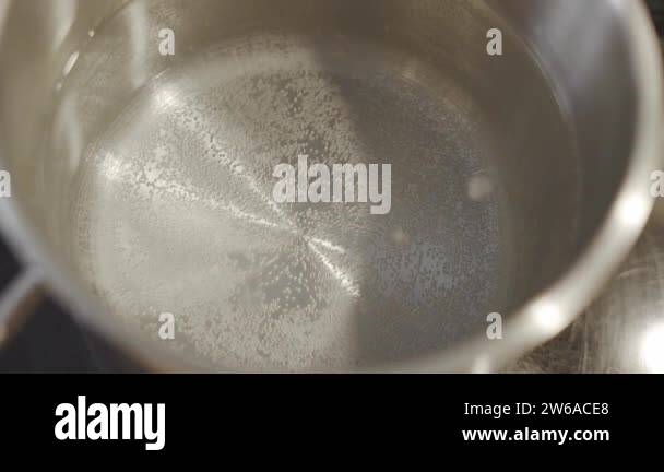 Hot water in a steel pan. Air bubbles at the bottom of boiling water ...