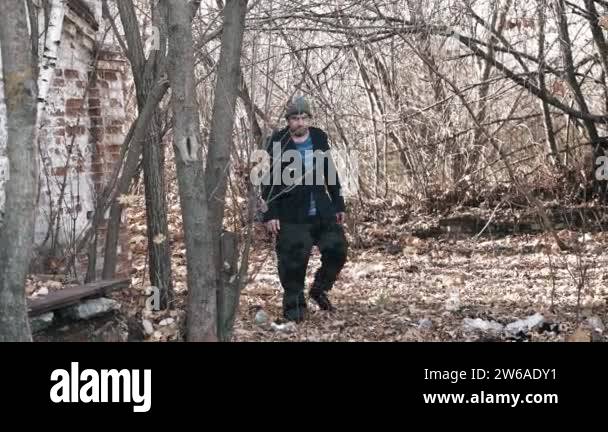 a hungry homeless unshaven man walks on the street in a torn suit a ...