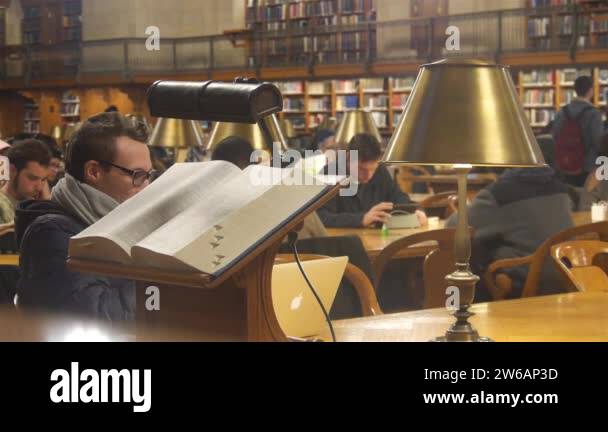 Open Book Exposed On Wooden Shelf In Front Of People Reading In Library ...