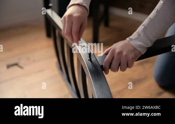Assembly of wooden furniture, a woman putting together the wooden parts ...