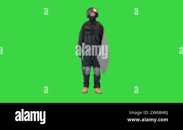 Special unit riot policeman with a shield and baton standing waiting on ...