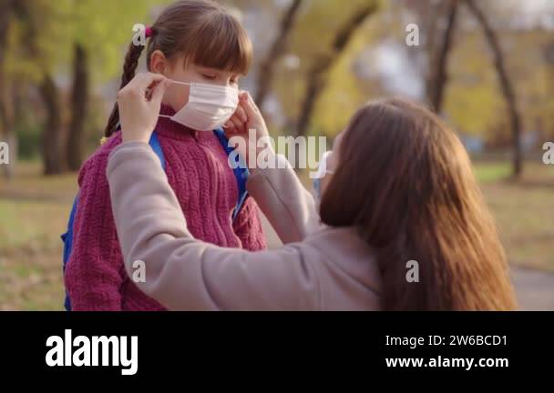 mother puts little child a medical mask on her face, protection against ...