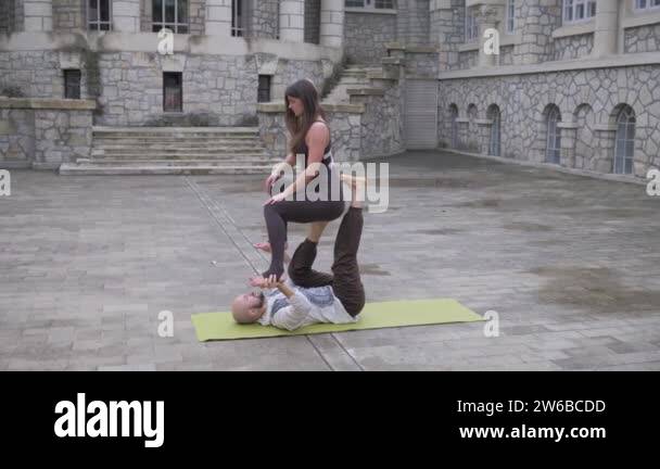 Fit sporty couple practicing acro yoga with partner together on mat ...
