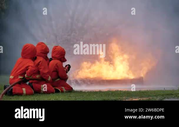 Firefighter fighting with fire flame protection property. Fireman wear ...