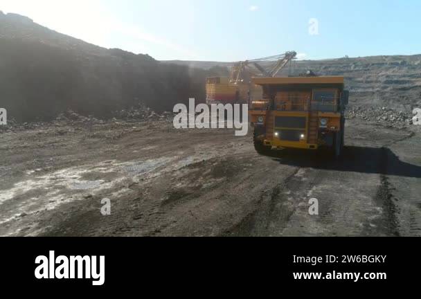 Large quarry dump truck. Loading rock in dumper. Loading coal into ...
