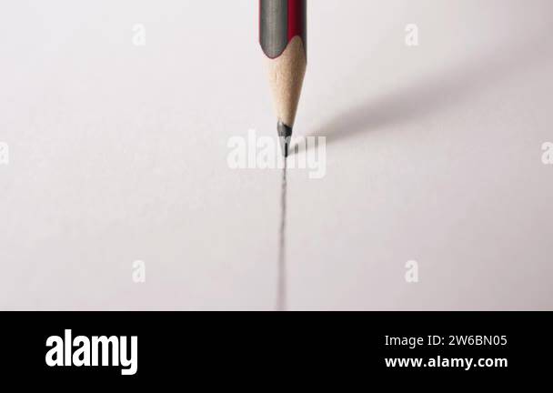 Tracking shot of pencil drawing straight line on smooth white surface ...