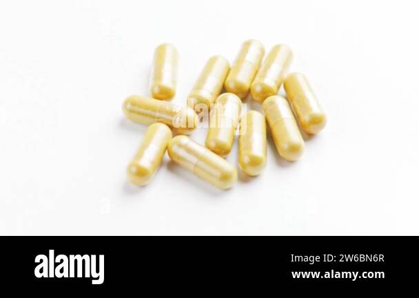 transparent capsules with brown dried organic powder inside close-up ...