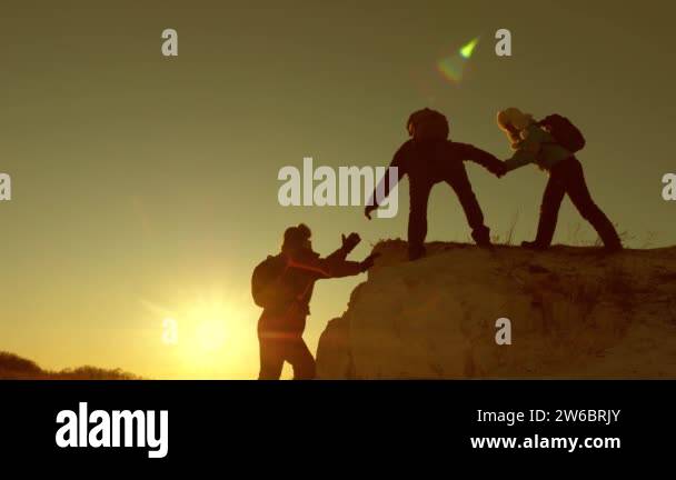 Travelers climb one after another on the rock. Teamwork of business ...
