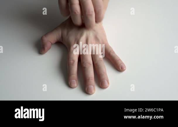A faceless adult male scratches his hand, which is isolated on a white ...