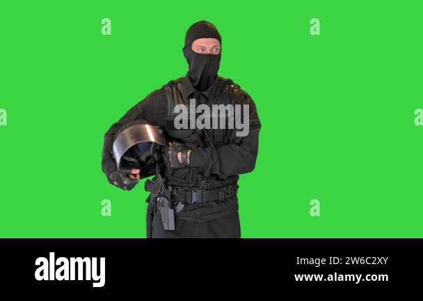 Riot policeman standing holding his helmet in hands on a Green Screen ...