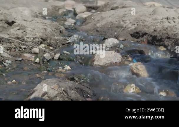 dirty water with waste flows into the river. dirt and silty discharge ...