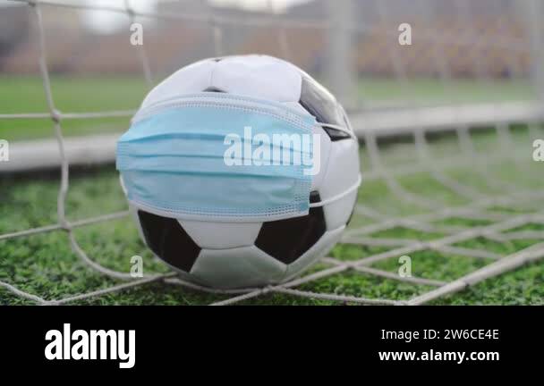 Soccer Ball in Medical Mask in Goal Net. Empty Stadium. Cancellation of ...