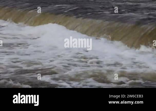 Industrial waterfall line Dam with foamy water flow close up diagonal ...