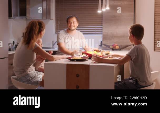 In the Kitchen: Family of Four having supper Together. Mother, Father ...