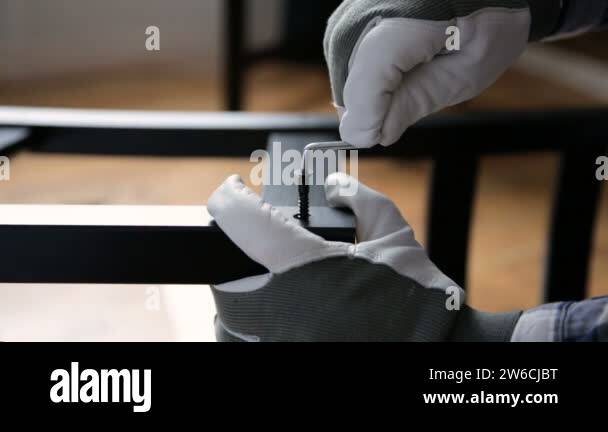 Assembly of wooden furniture, a man putting together the wooden parts ...