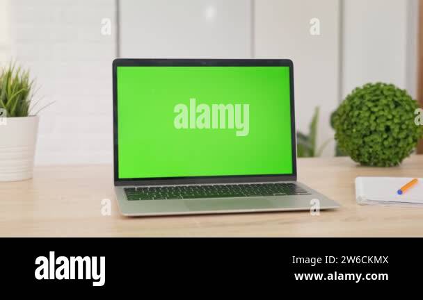 Modern laptop with mock up chroma key green screen on table of living ...