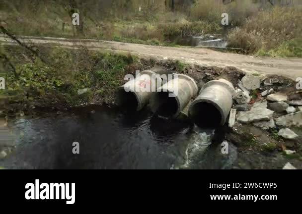 Concrete waste pipes. Streams of water flow through concrete pipes ...
