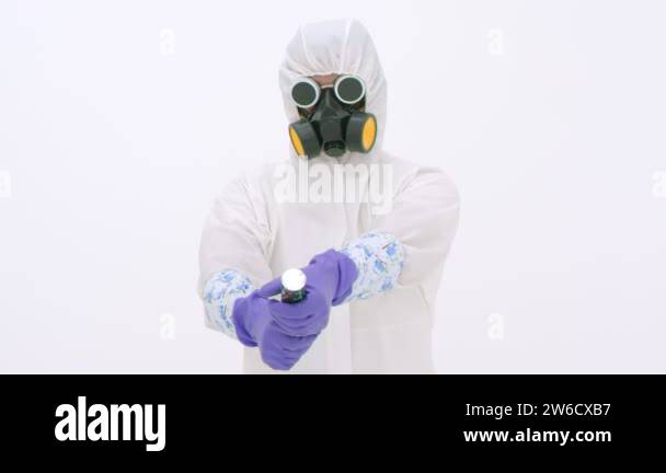 Man in white chemical protection suit and gas mask blows the party ...