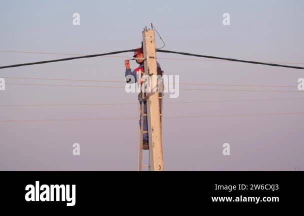 electrical engineer performs installation work on a concrete pillar ...