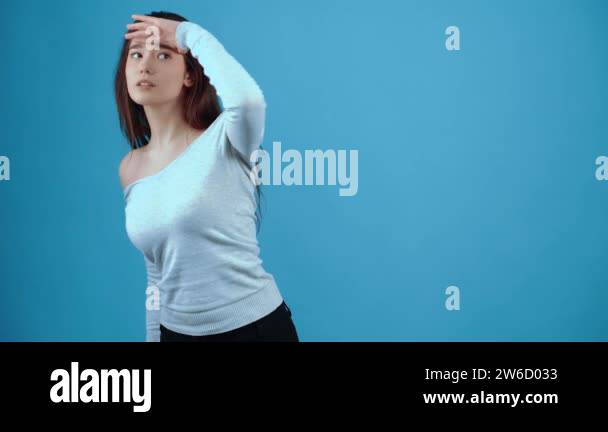The confident young brunette looks around suspiciously with her hand ...