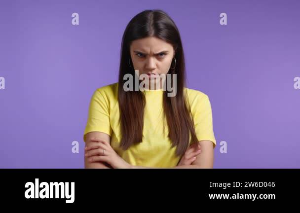 Angry offended woman keeping arms crossed and staring at camera with ...