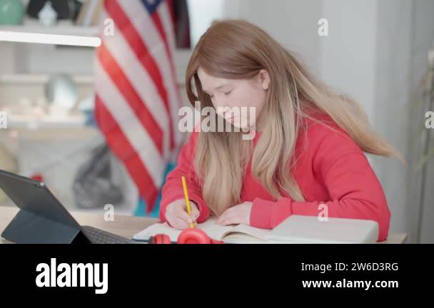 Concentrated genius Asian teen girl doing homework sitting at table ...