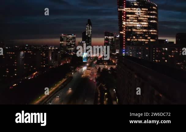 Night city scene, High rise illuminated buildings along wide street ...