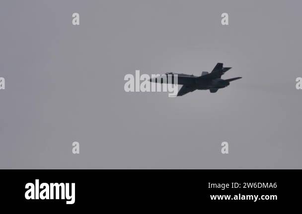 Black silhouette of a modern military fighter jet in flight in slow ...