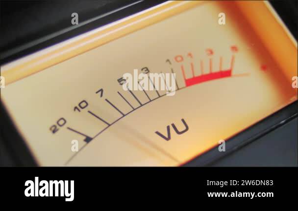 Close up full frame a highlighted analog VU meter with moving needle. A ...