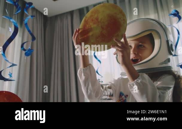 Girl astronaut in the form in a bumblebee astronaut costume is playing ...
