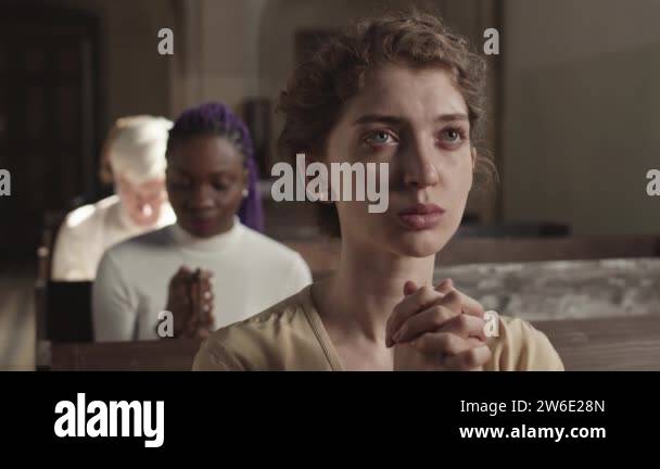 Lockdown of young Caucasian woman sitting on pew in Christian church ...