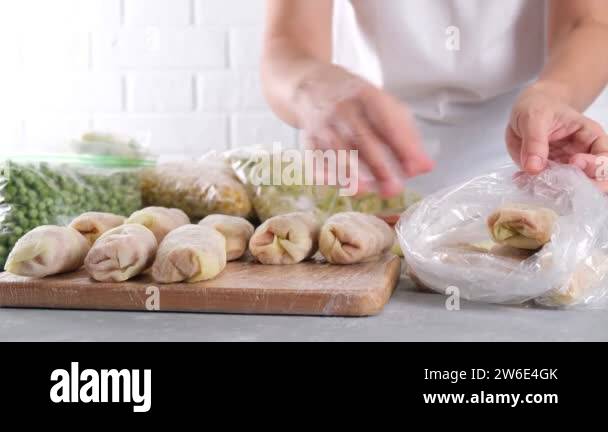 Frozen food. Woman packing frozen stuffed cabbage roll in a bag on the ...